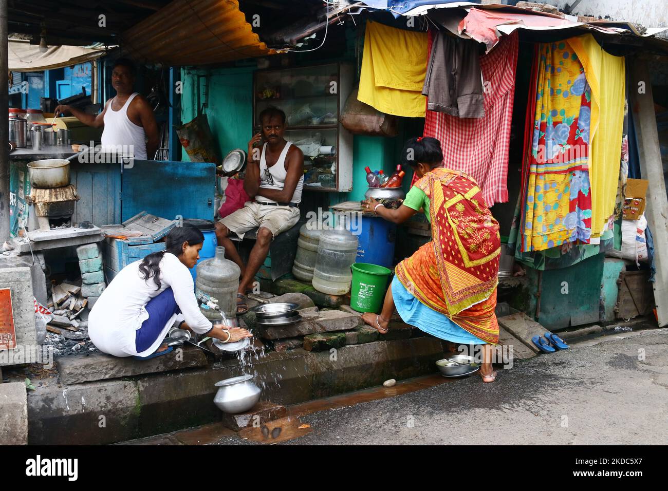 Indian slum dwellers fill containers with drinking water provided by ...