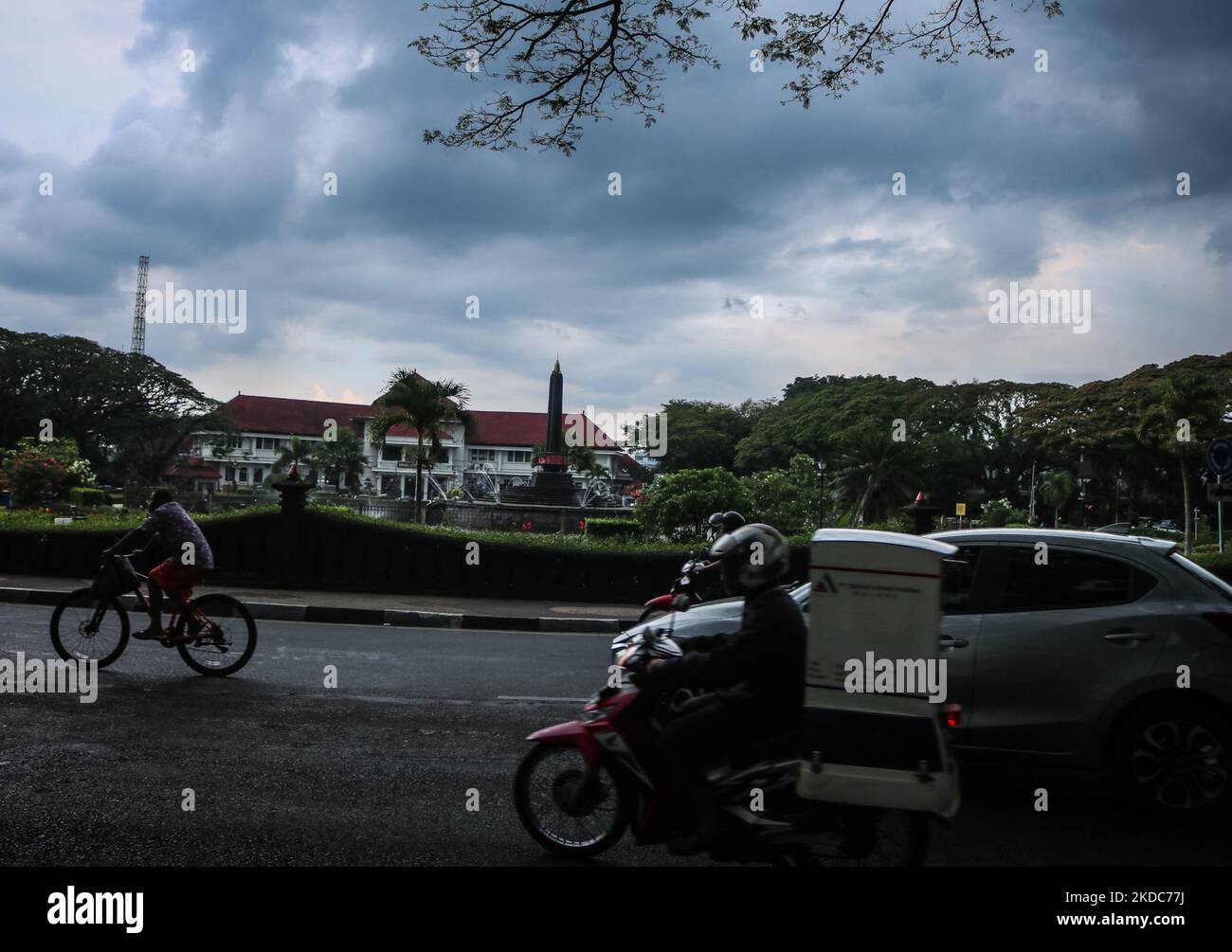 Residents pass by when the weather is cloudy in the square of Malang ...
