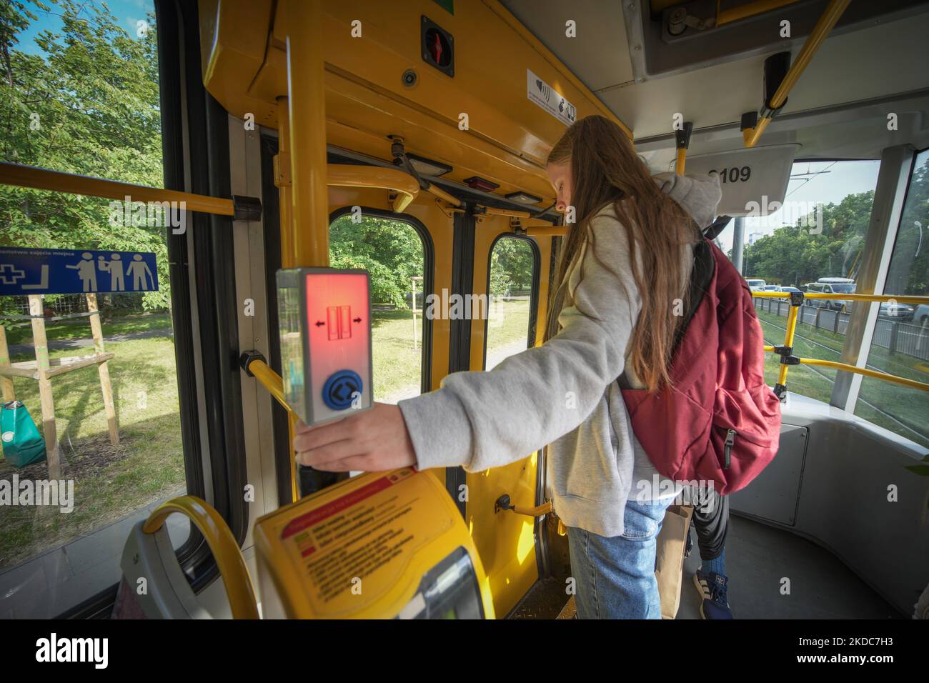 A young woman is seen pressing the stop button in a public ...
