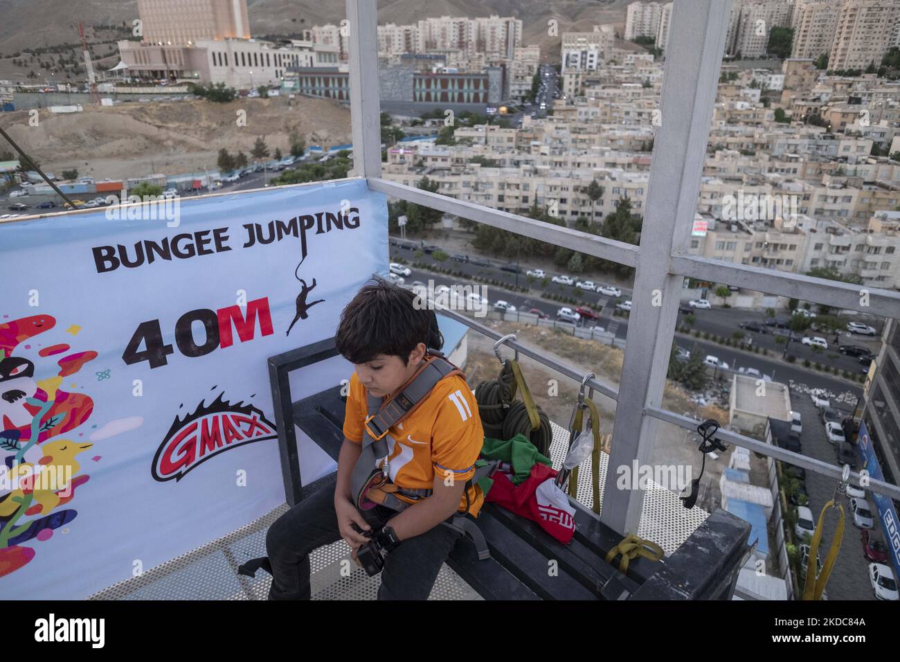 Iranian 11-year-old bungee boy, Nikan Zareian, sits on a 40-meter rig ...