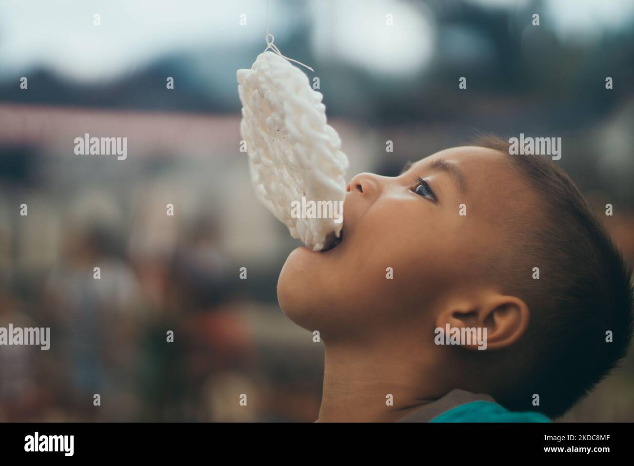 A child playing a game, trying to eat the hanging cracker in order to ...