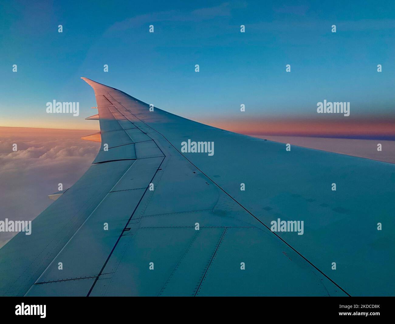 The wing of an airplane in the air at soft pink sunset Stock Photo - Alamy