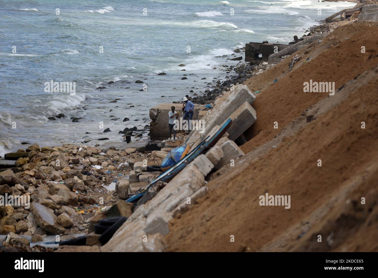 Palestinian construction workers build a seawall, from the rubble of ...