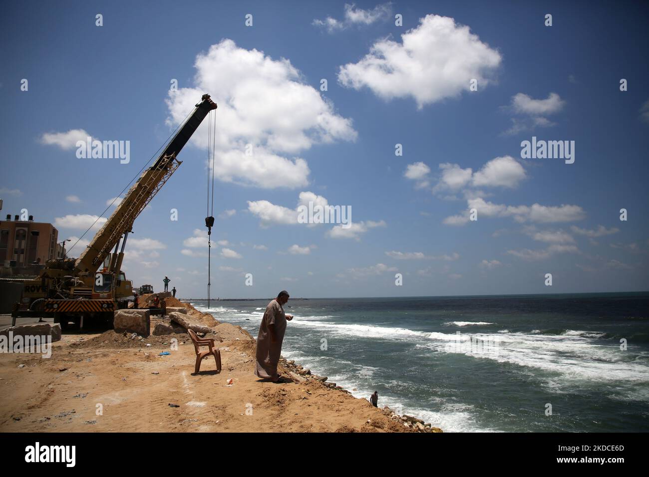 Palestinian construction workers build a seawall, from the rubble of ...