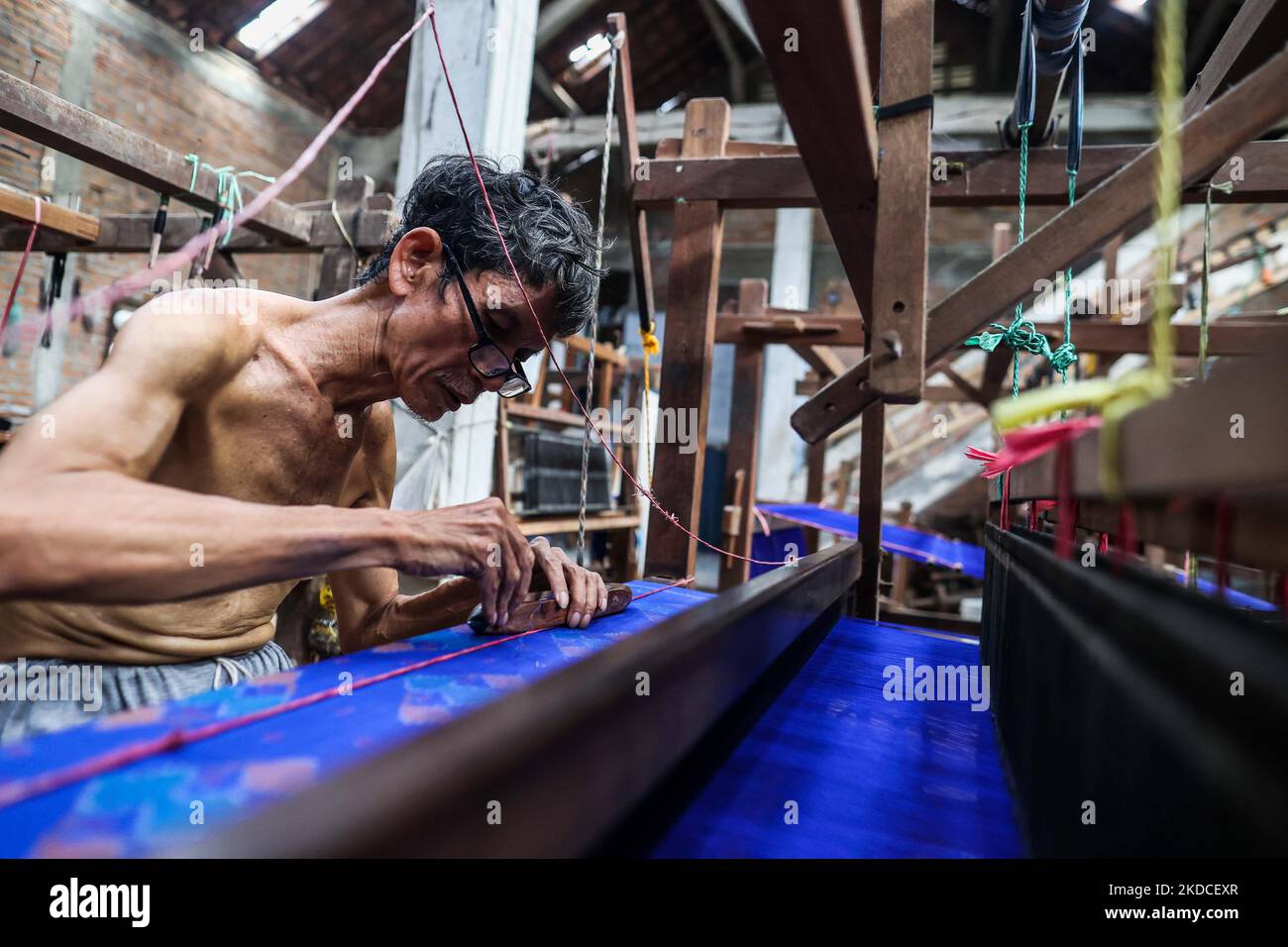 A worker weaver making textiles at the traditional weaving workshop at Troso village in Jepara ...