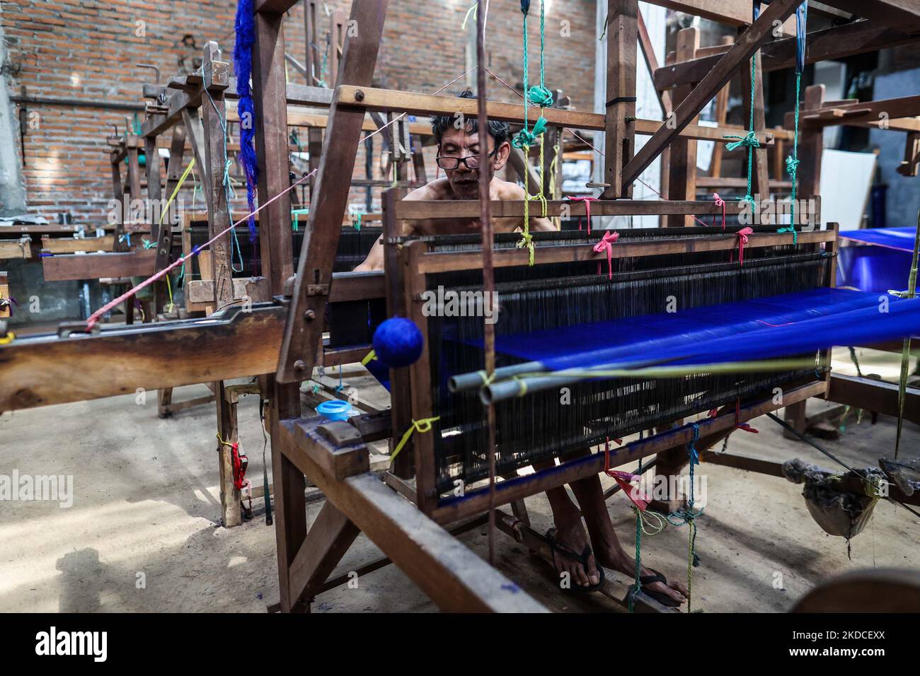 A worker weaver making textiles at the traditional weaving workshop at ...