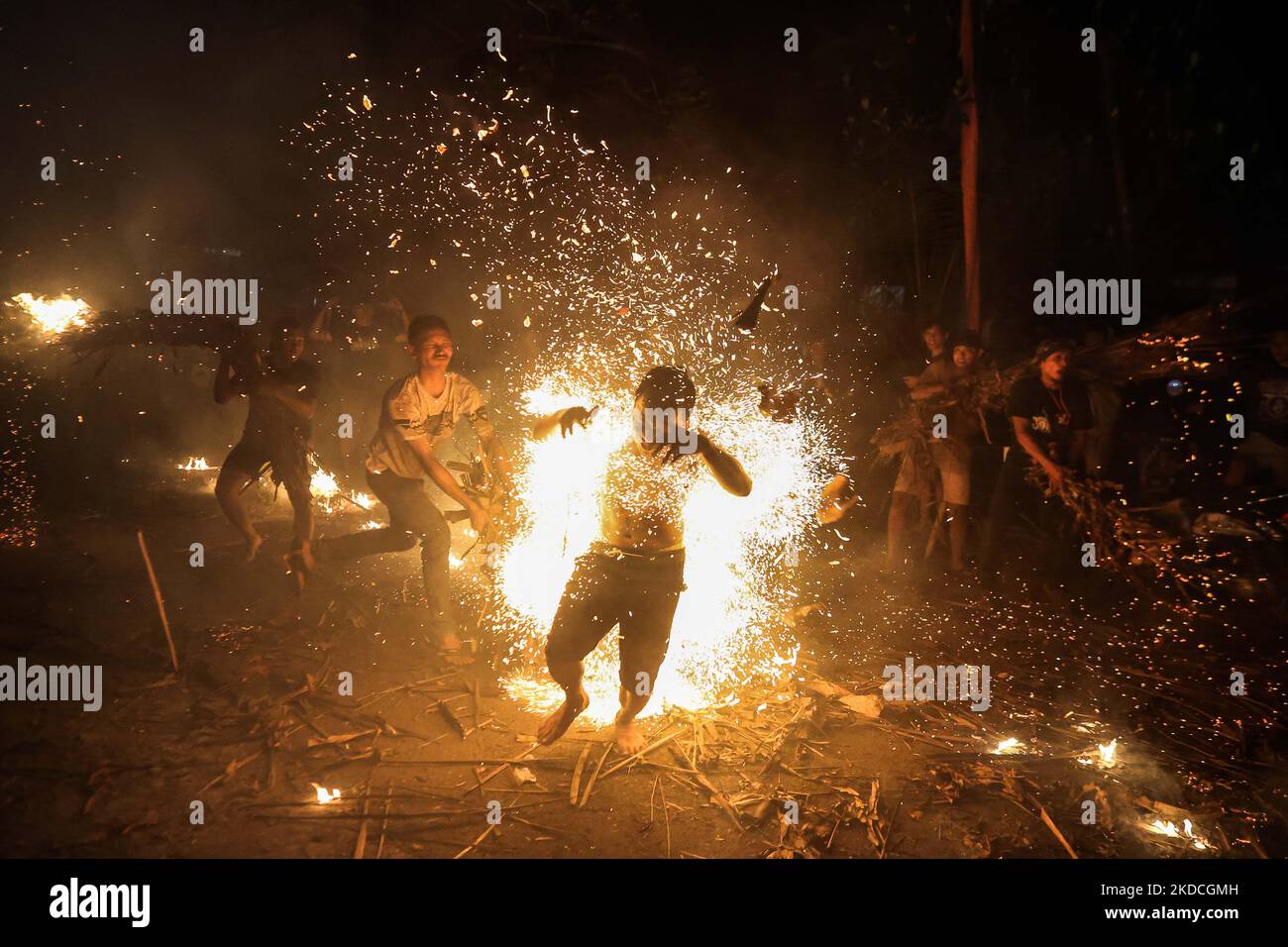 A man hits another with burning dried coconut leaves during a fire ...