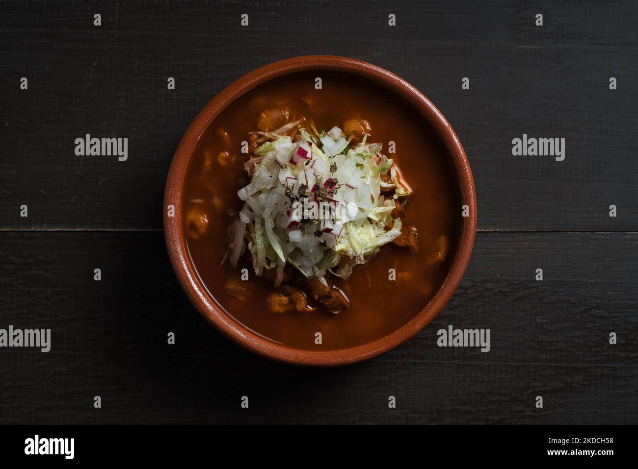 A top view of a bowl of Pozole Rojo (Mexican Pork and Hominy Stew) on a ...