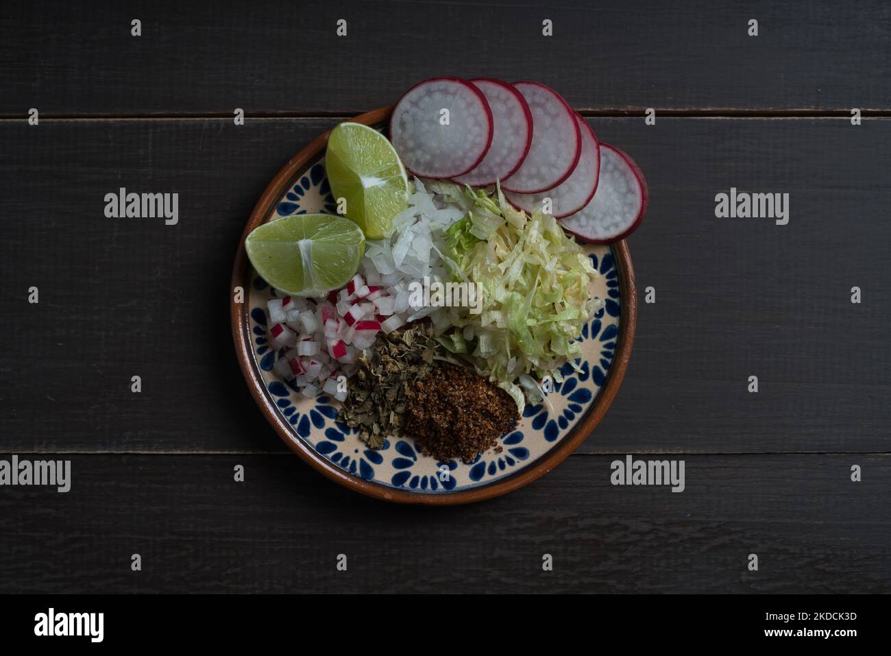 A top view of a plate with vegetables and herbs for Pozole Rojo ...