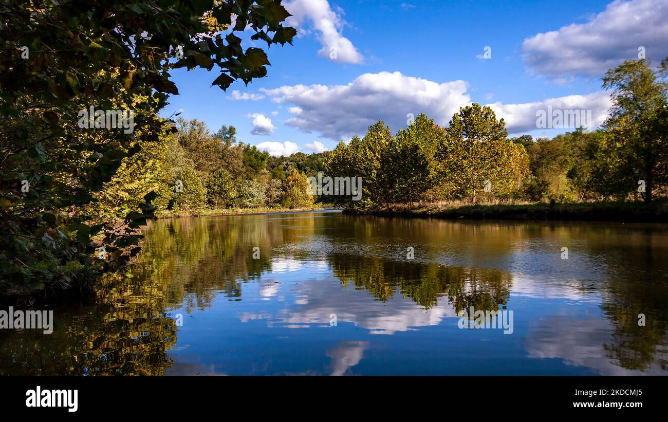 Landscape with lake reflecting cloudy sky and rock bluffs at Klondike ...