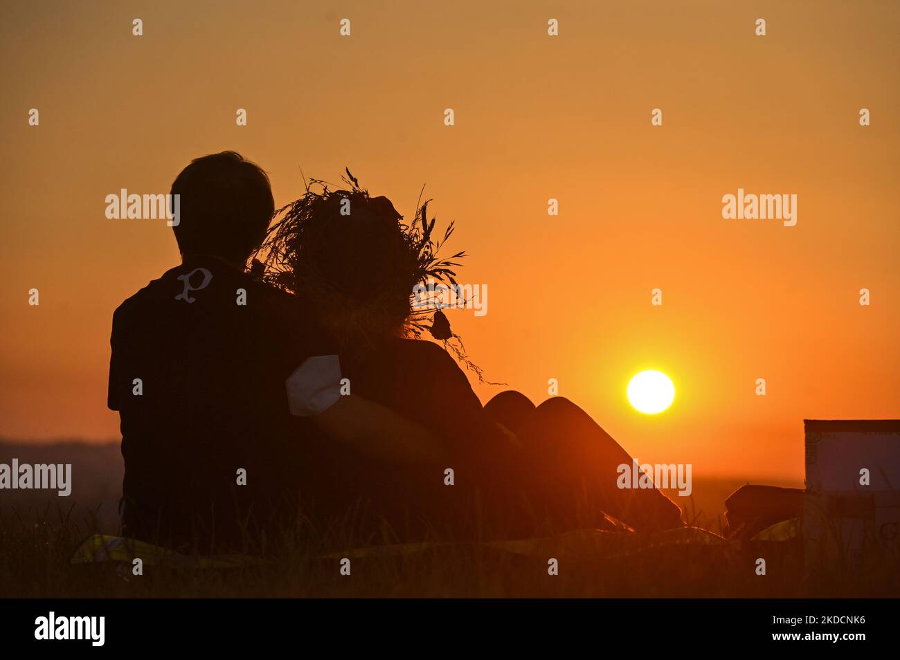 A couple watching the sunrise next to the Krakus Mound in Krakow. On ...