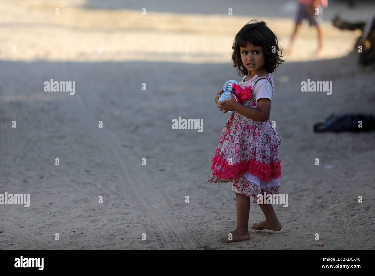 A Palestinian girl carries agallons with water in Beit Hanun in the ...