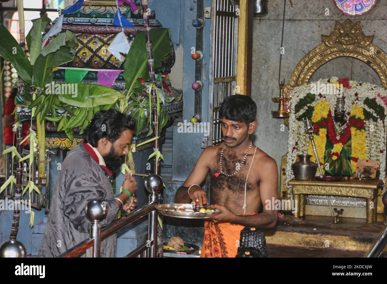 Tamil Hindu priest performs prayers at a small roadside temple in ...