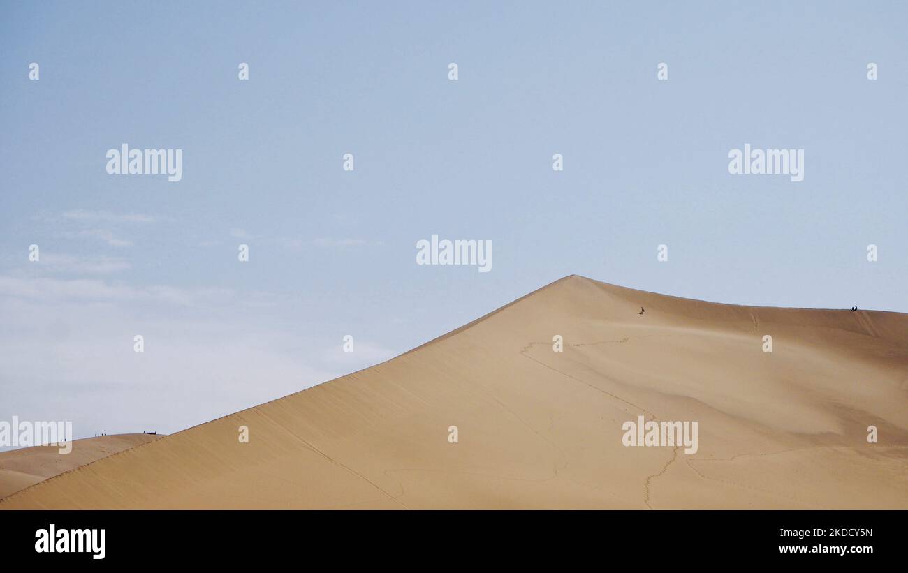 A low-angle of sunlit sand hills in the horizon, clear sky background ...