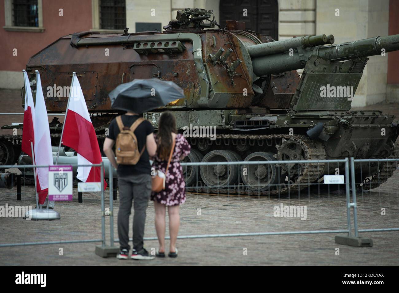 A couple holding an umbrealla is seen looking at a Russian Howitzer ...