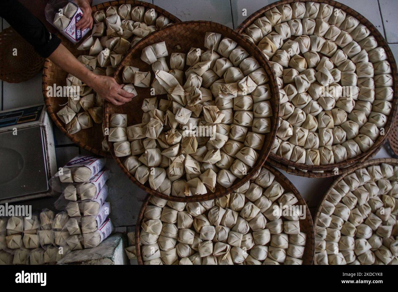 A woman is seen packing traditional Wajit food on June 29, 2022, in ...