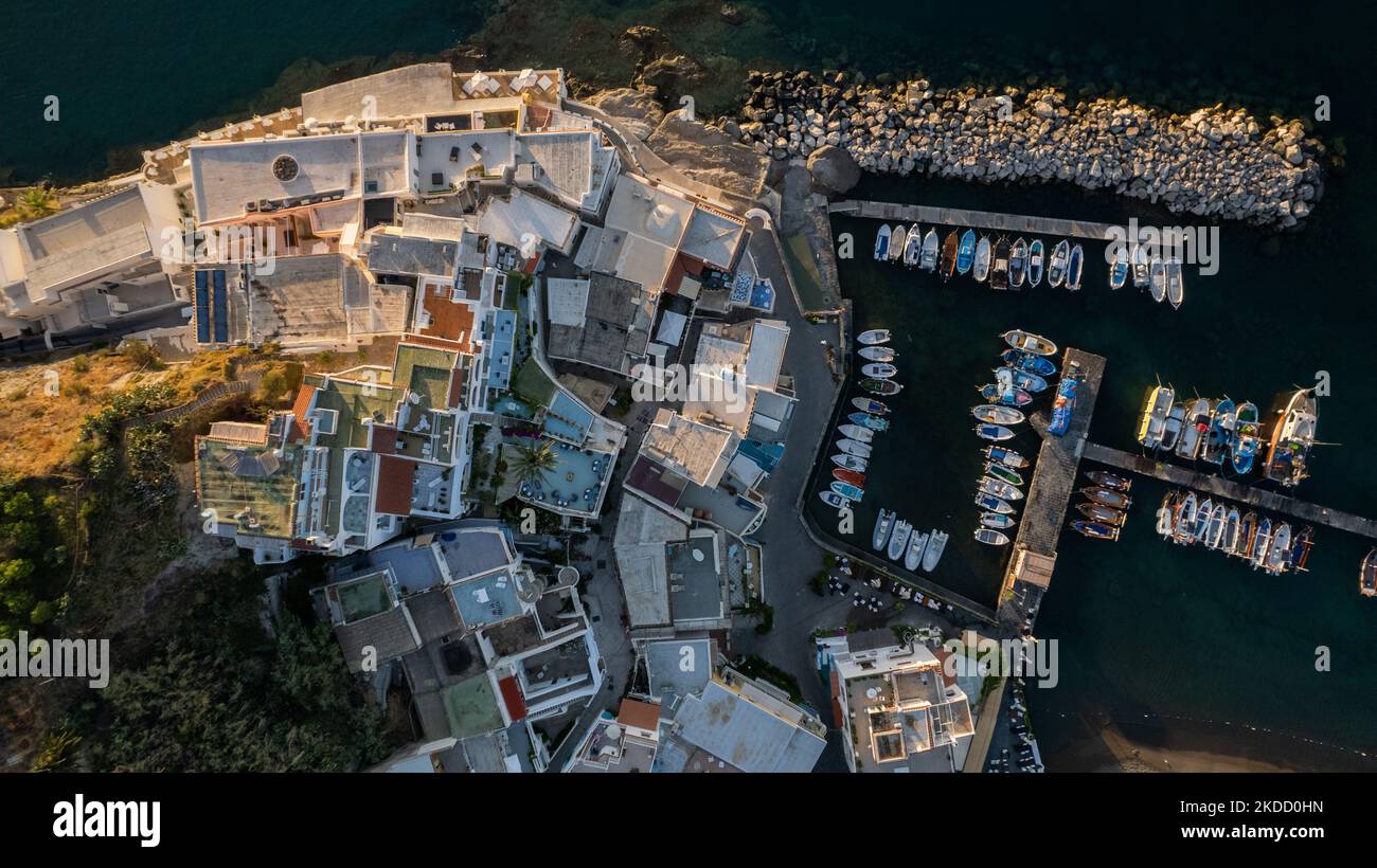 A drone view of houses and the port of Ischia Sant'Angelo at sunrise ...
