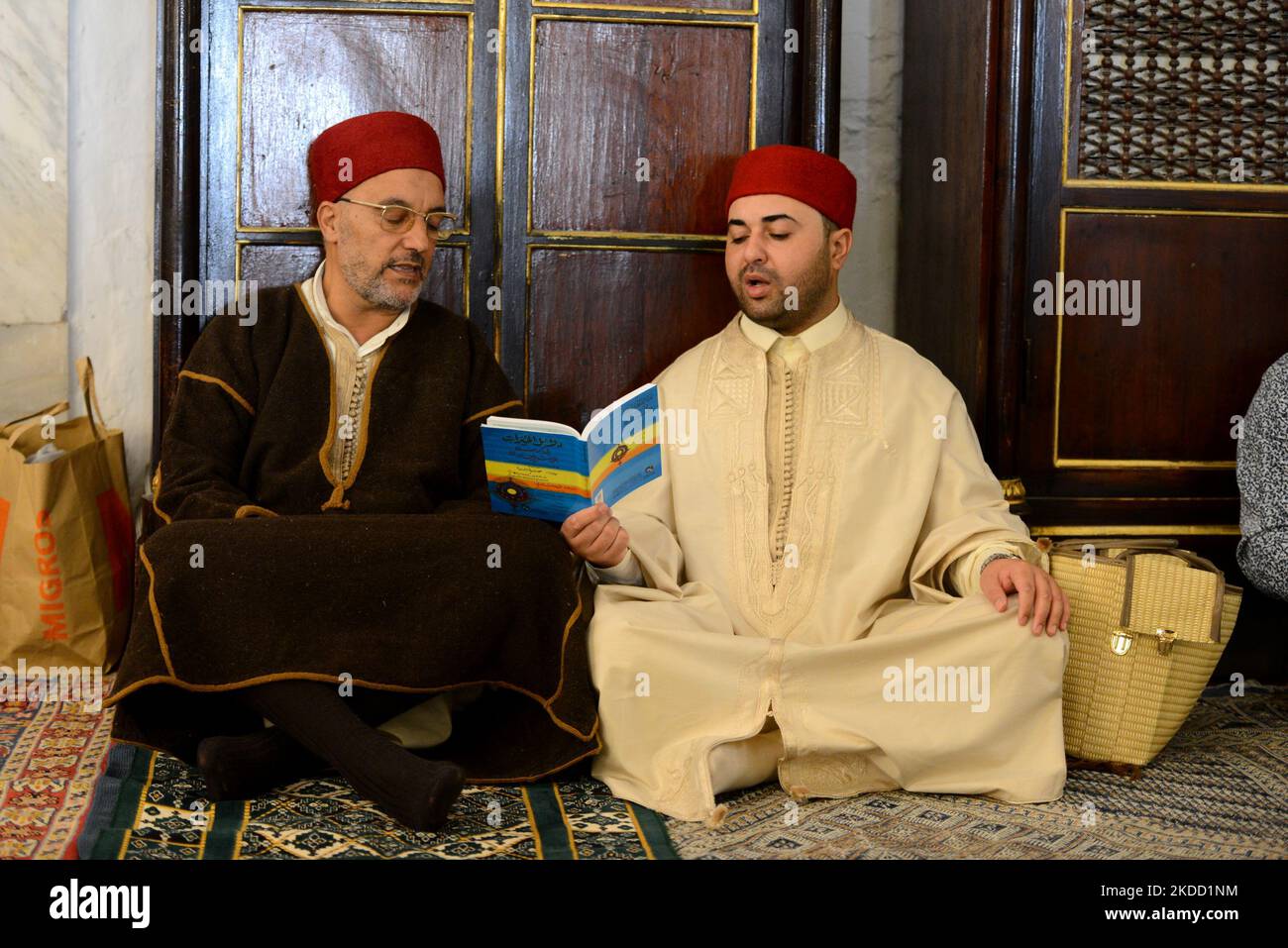 Two Muslim men reading the Holy Quran before the Friday prayer at Al ...