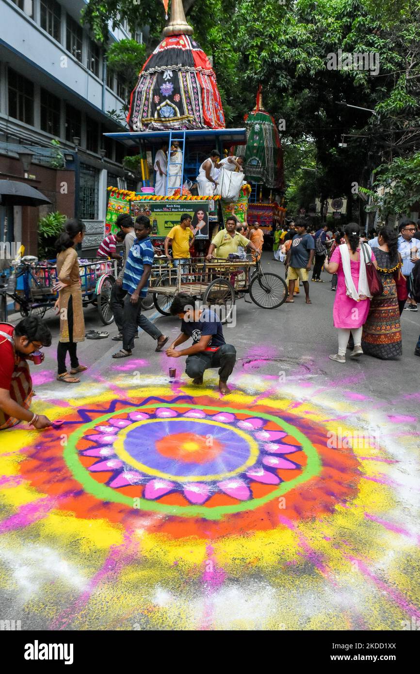 Devotees are seen drawing rangoli in front of a chariot outisde ISCKON ...