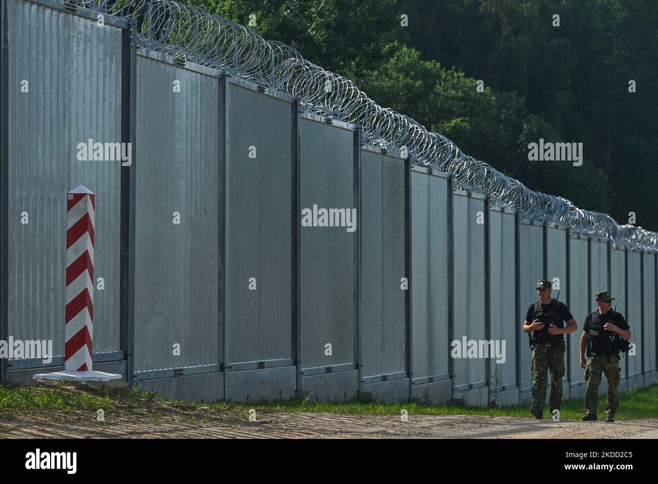 Polish border guards near the new fence on the Polish-Belarusian border ...