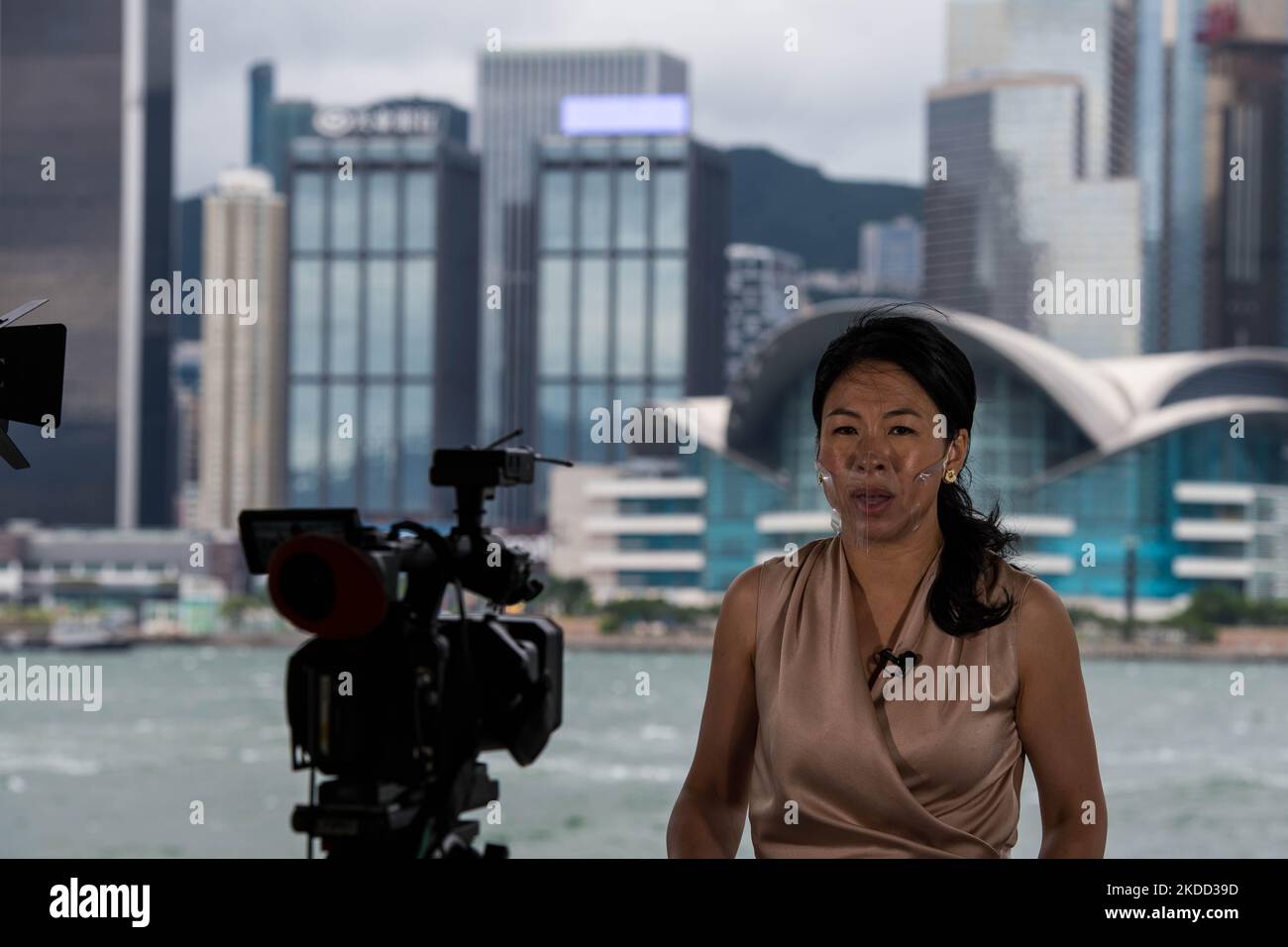 A TV reporter starts a live report from Tsim Sha Tsui in front of the ...