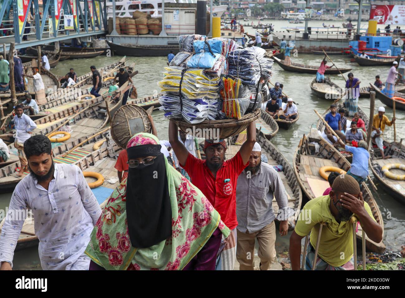 Boatmen carry passengers to cross the river Buriganga in Dhaka, Bangladesh on July 2, 2022 ...