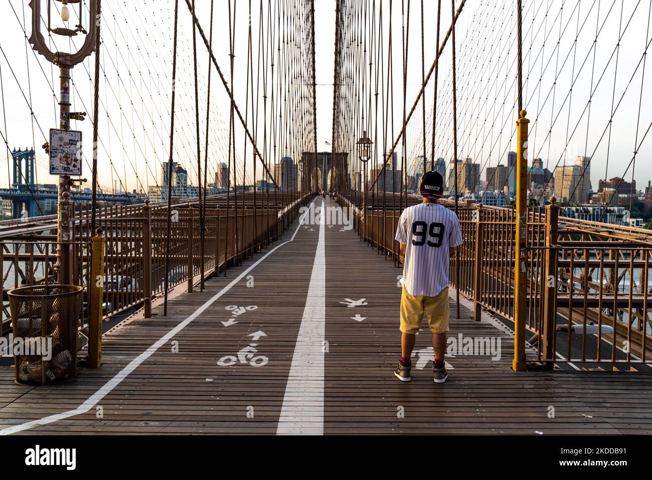 A person standing on the Brooklyn Bridge at sunrise Stock Photo - Alamy