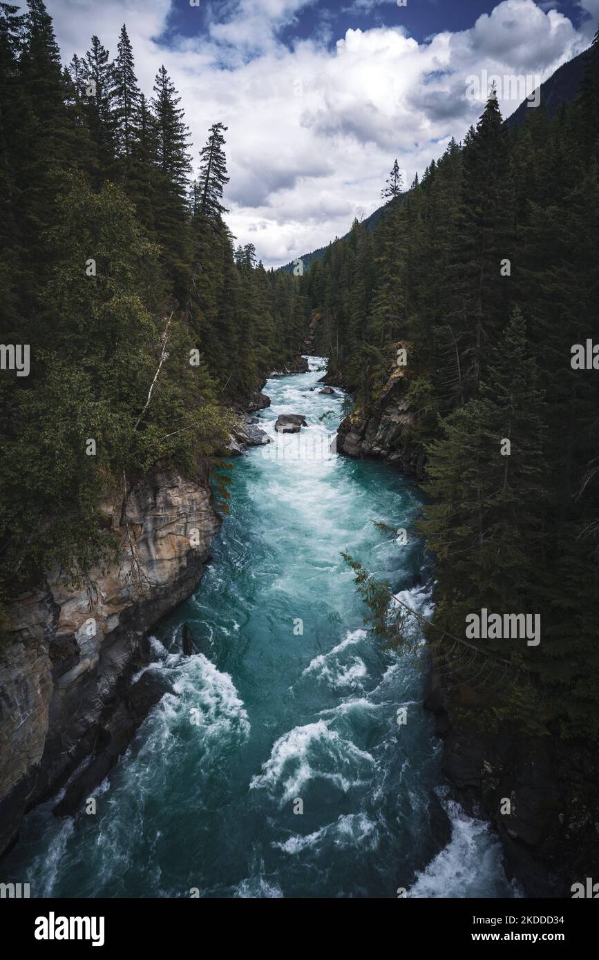A vertical view of a river surrounded by mountain ranges in Canada ...