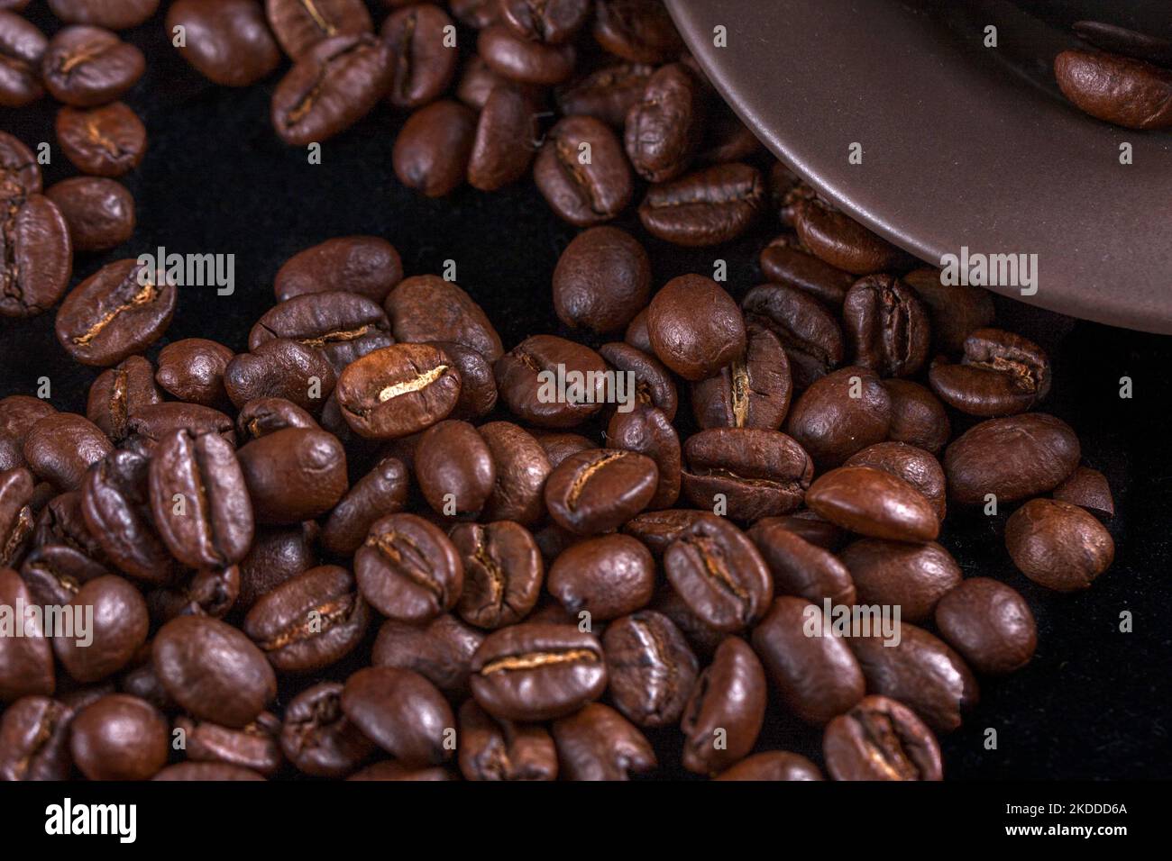 A top view of coffee beans with a coffee cup isolated on a dark ...