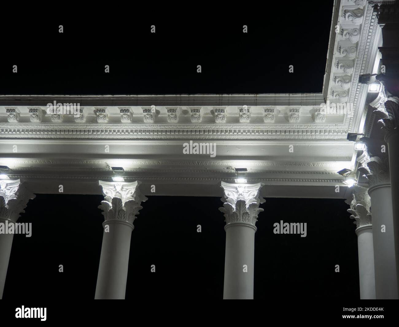 White colonnade in the dark. White columns in the light of spotlights ...
