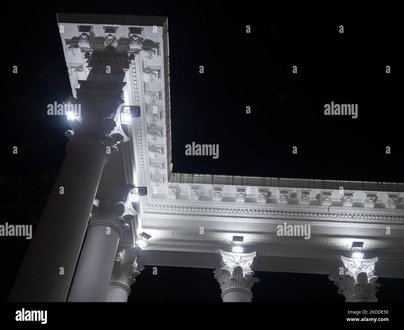 White colonnade in the dark. White columns in the light of spotlights ...