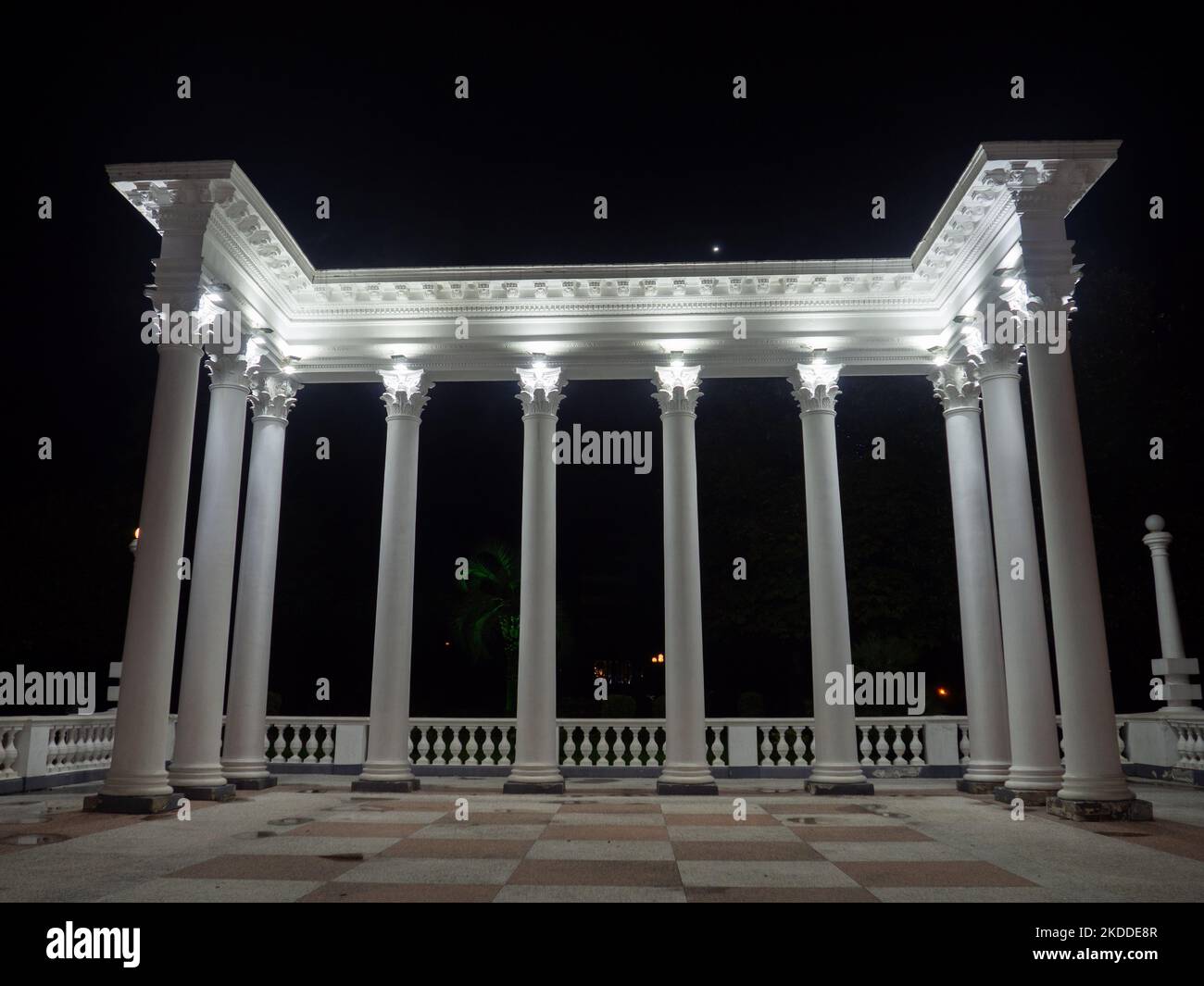 White colonnade in the dark. White columns in the light of spotlights ...