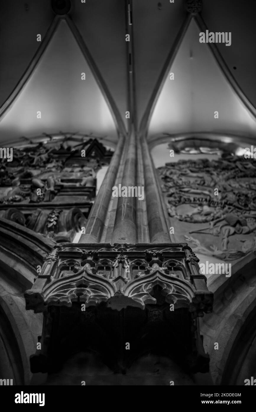 A vertical low angle grayscale of a detailed gothic styled interior ...