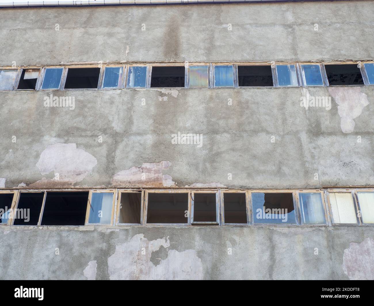 Old abandoned industrial building. Broken windows. Gray Soviet building ...