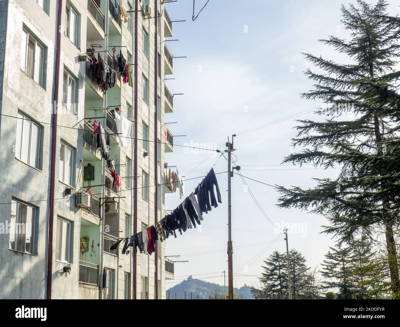 Colorful street. Yard with stretched clotheslines. Clothes are dried in ...