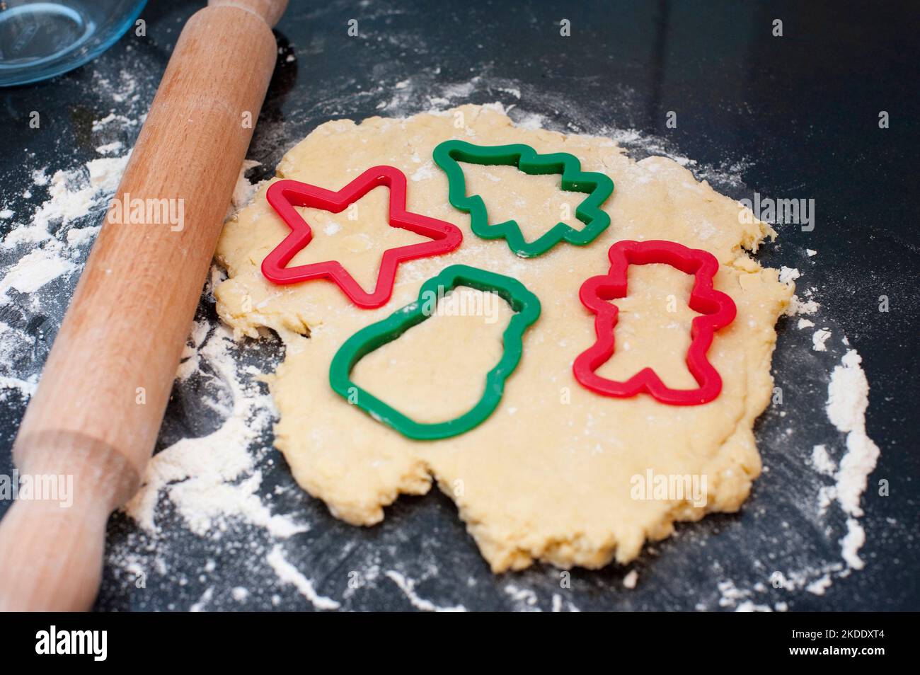 Rolled pastry dough with cookie cutters in traditional Christmas shapes ...