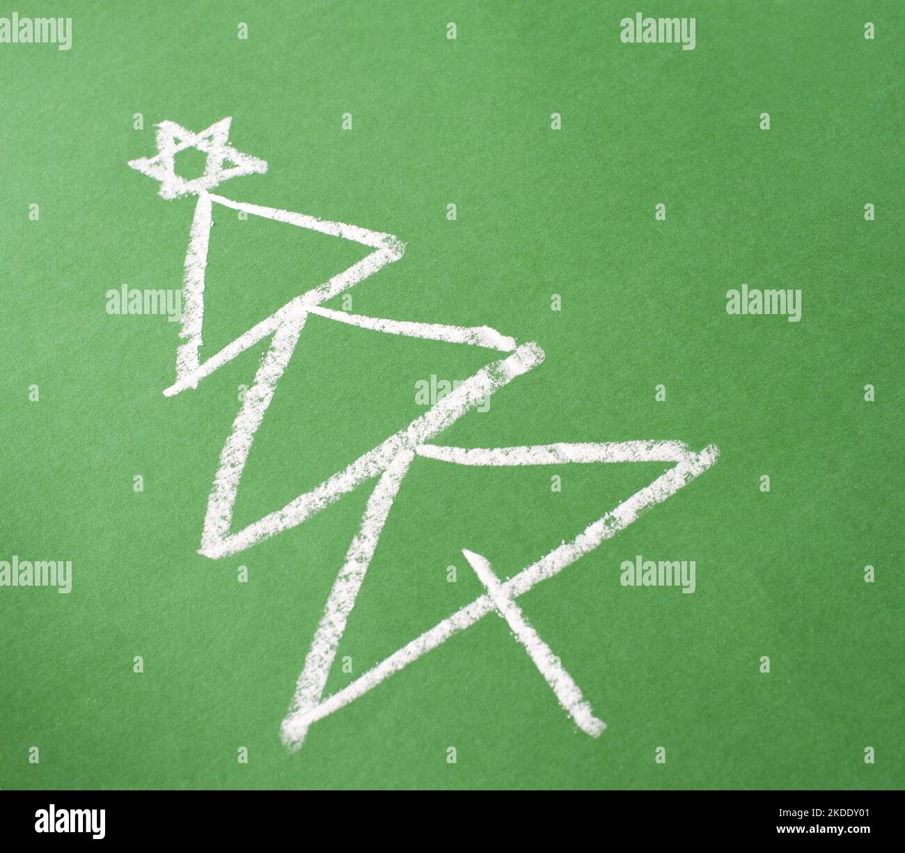 Simple hand-drawn chalk Christmas tree on a green blackboard with ...