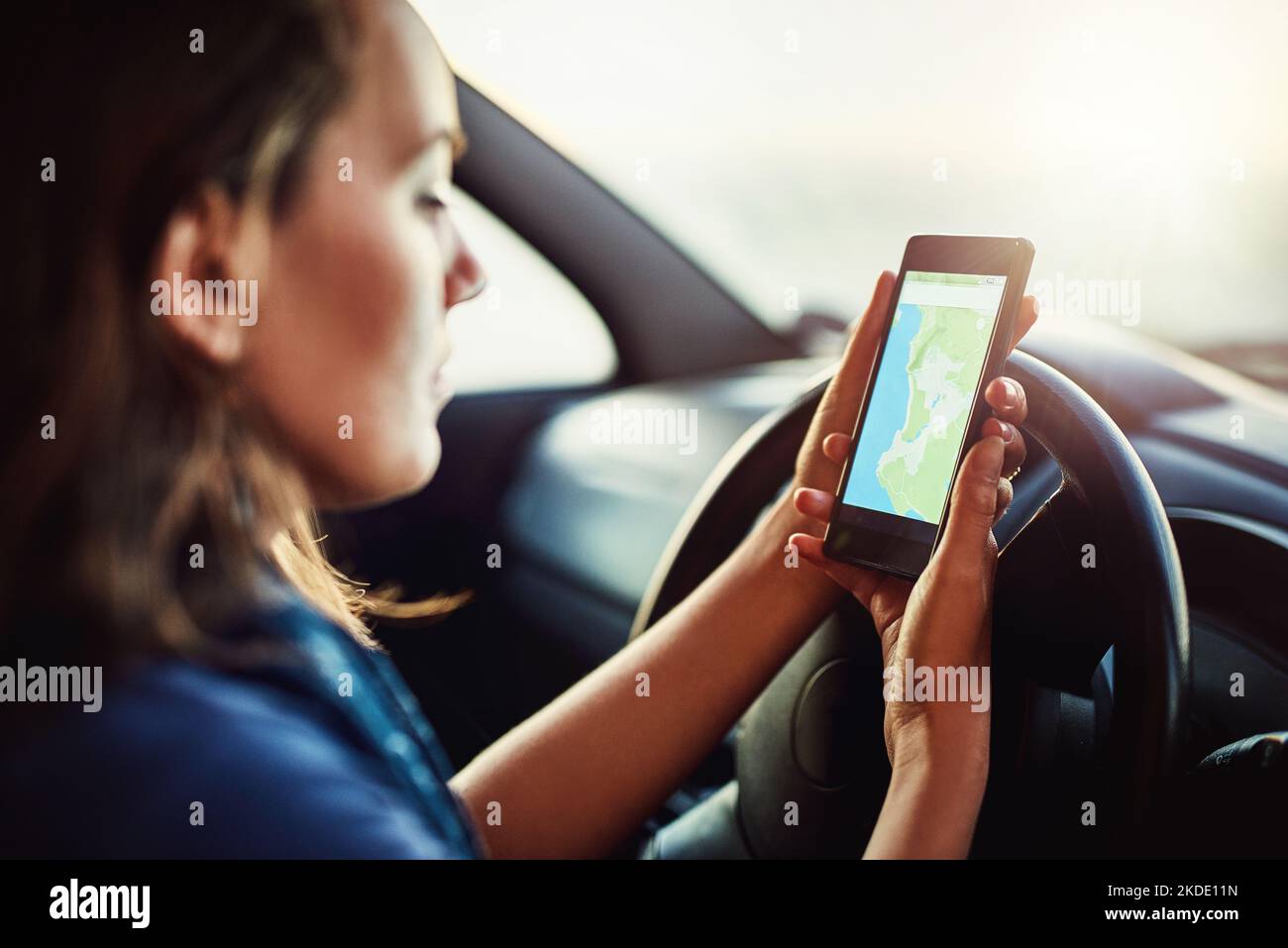 Finding her way around. a young woman using her cellphone to find ...