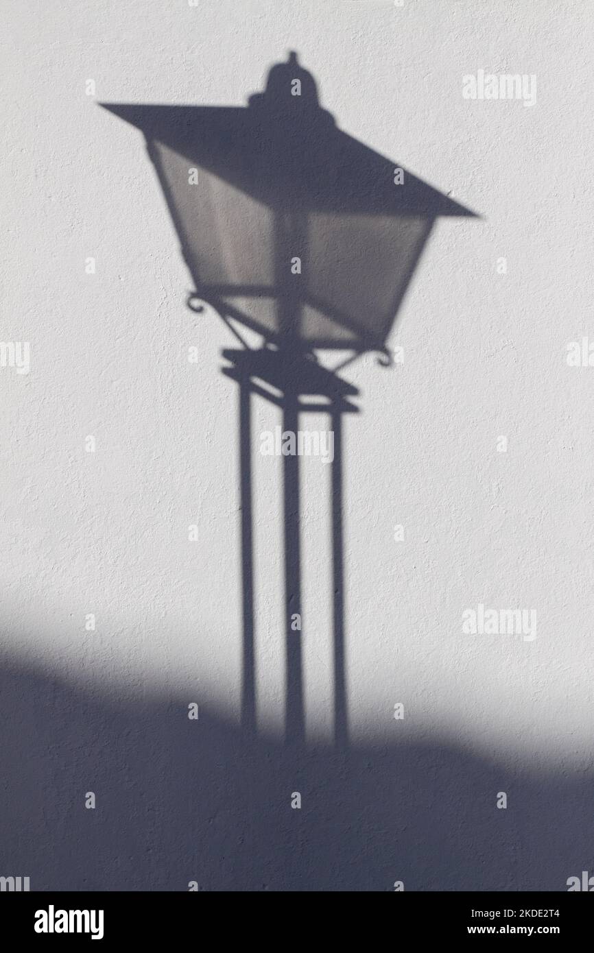 Old street lamp shadow projected in a white wall Stock Photo - Alamy