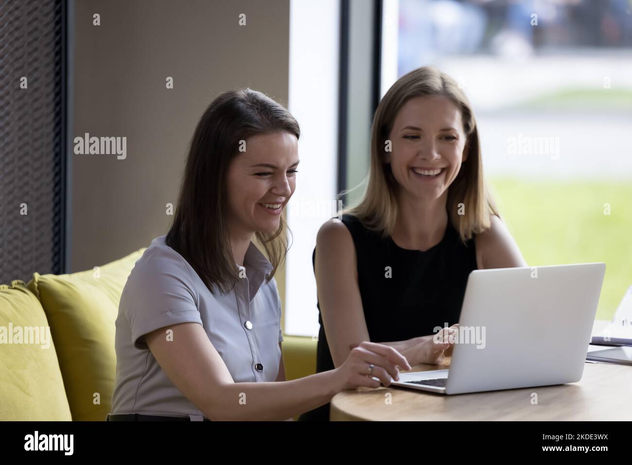 Attractive women sit at table staring at laptop at workplace Stock ...
