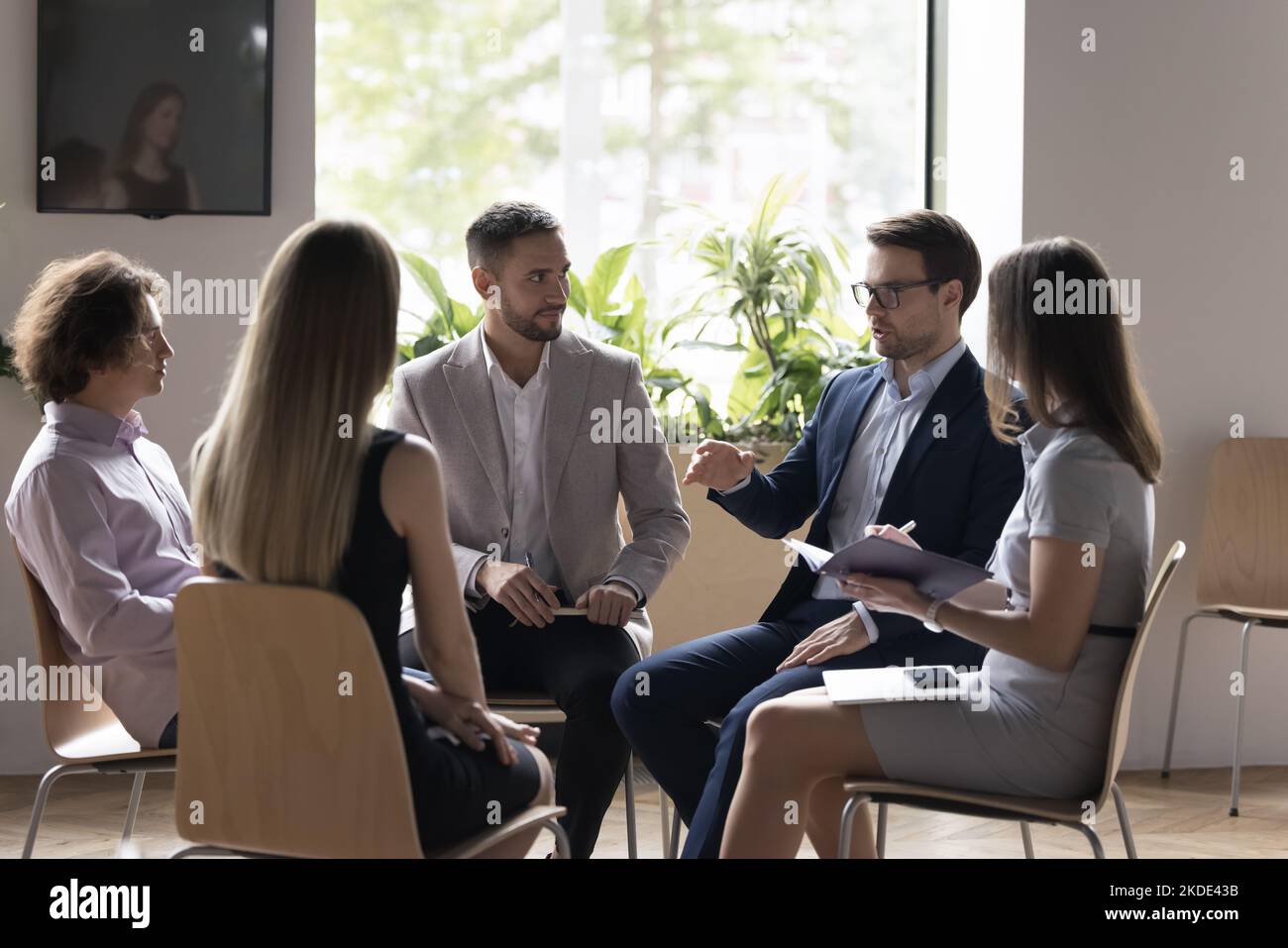 Staff members communicating during corporate briefing in office Stock ...