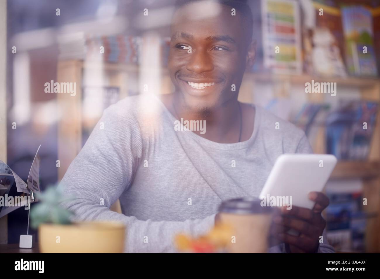 Give wifi. Get customers. a handsome young man using his tablet while ...