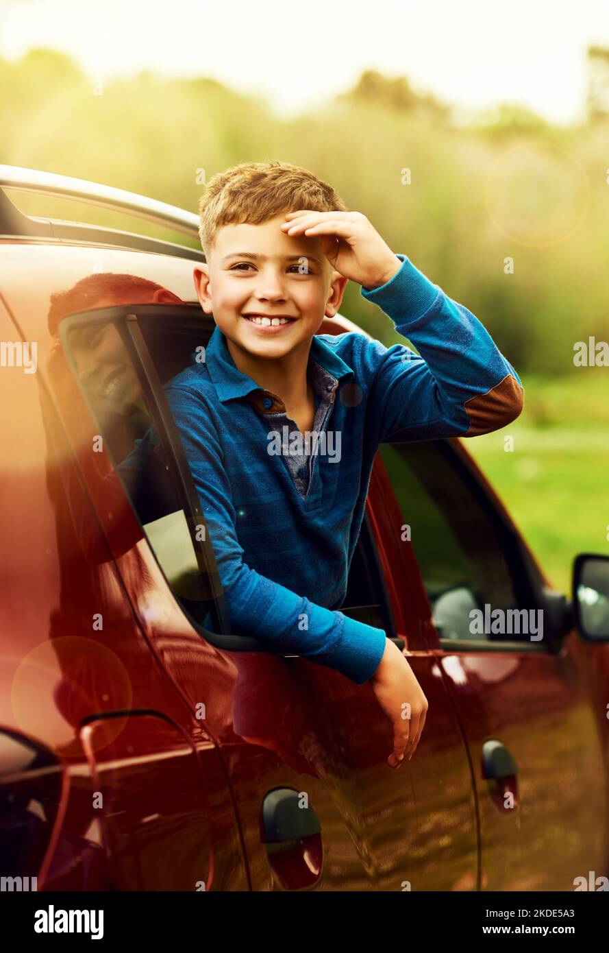 Are we there yet. Portrait of an adorable little boy leaning out of a ...