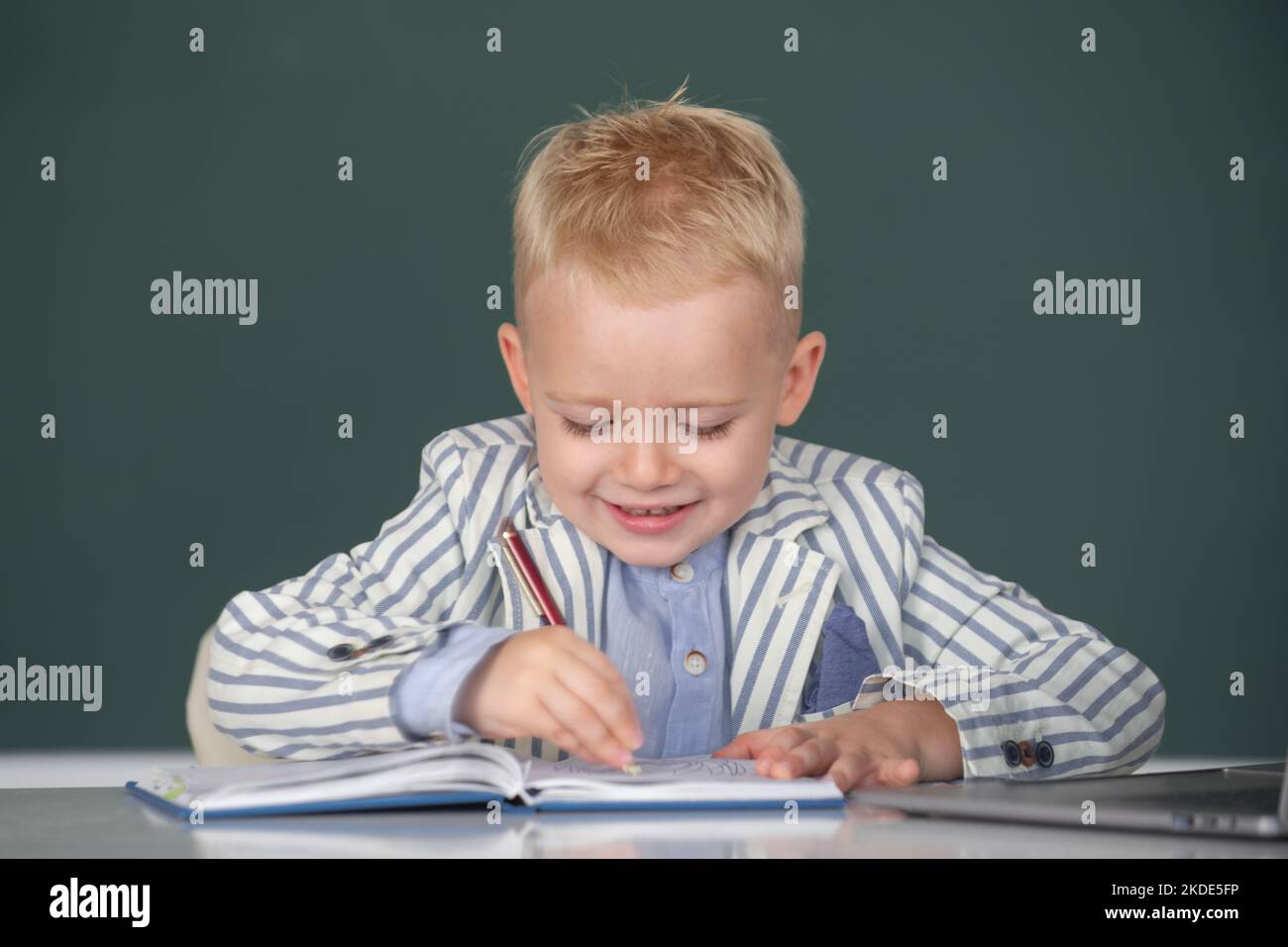 Kid writing in class. Portrait of funny pupil of primary school study ...