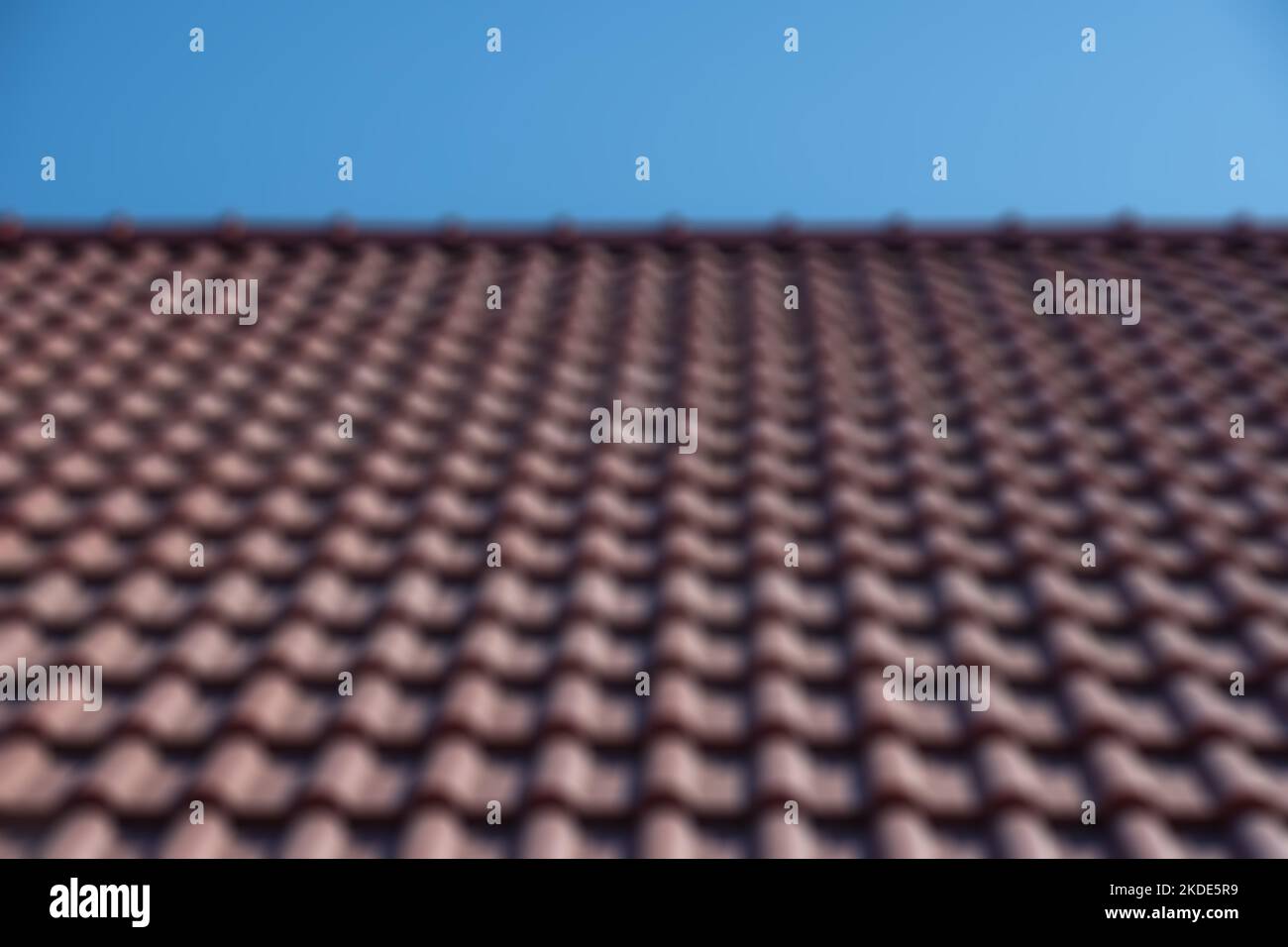 Abstract defocused blured background Brown tile roof under blue sky ...