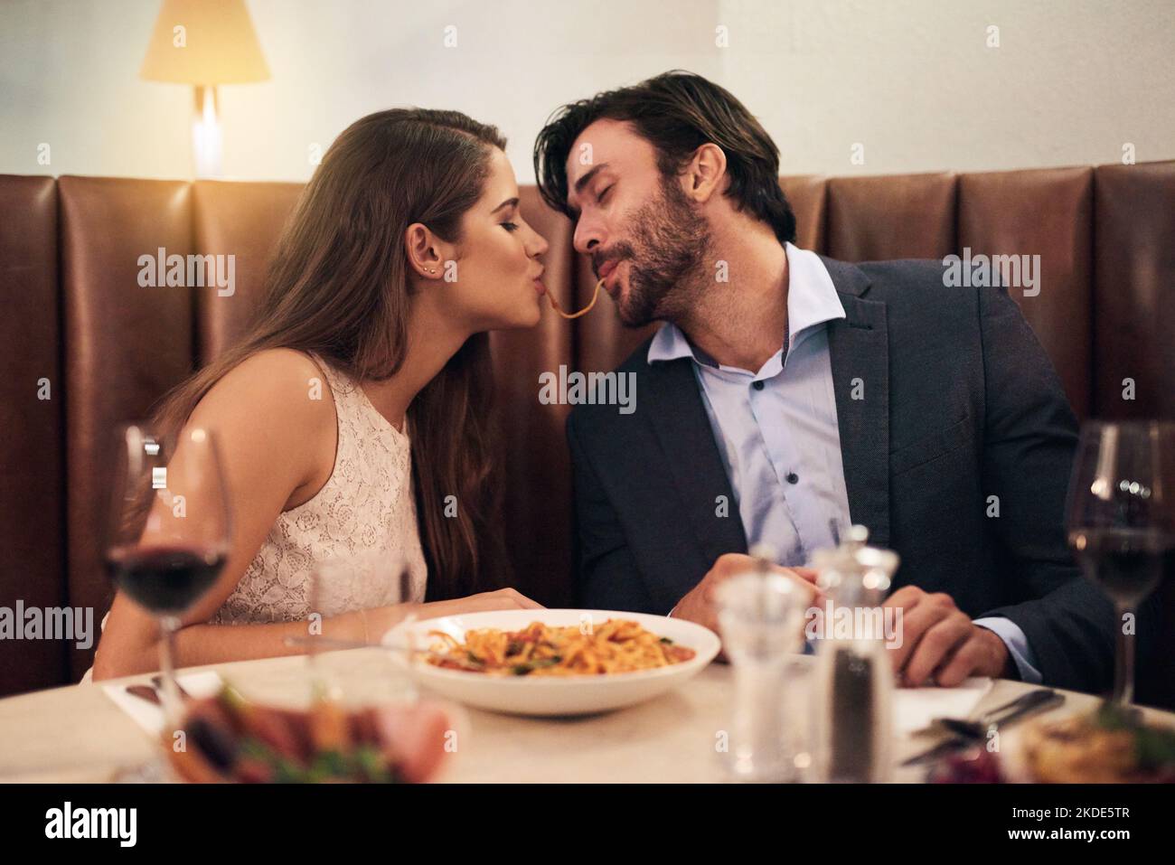 The middle is where it gets delicious. a young couple sharing spaghetti ...