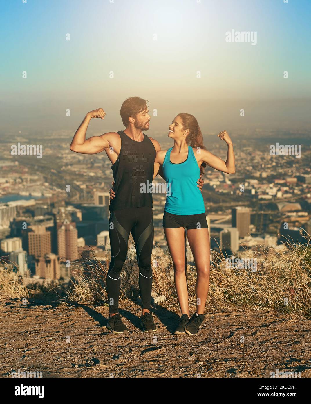 Be each others inspiration. a young couple flexing their muscles while ...