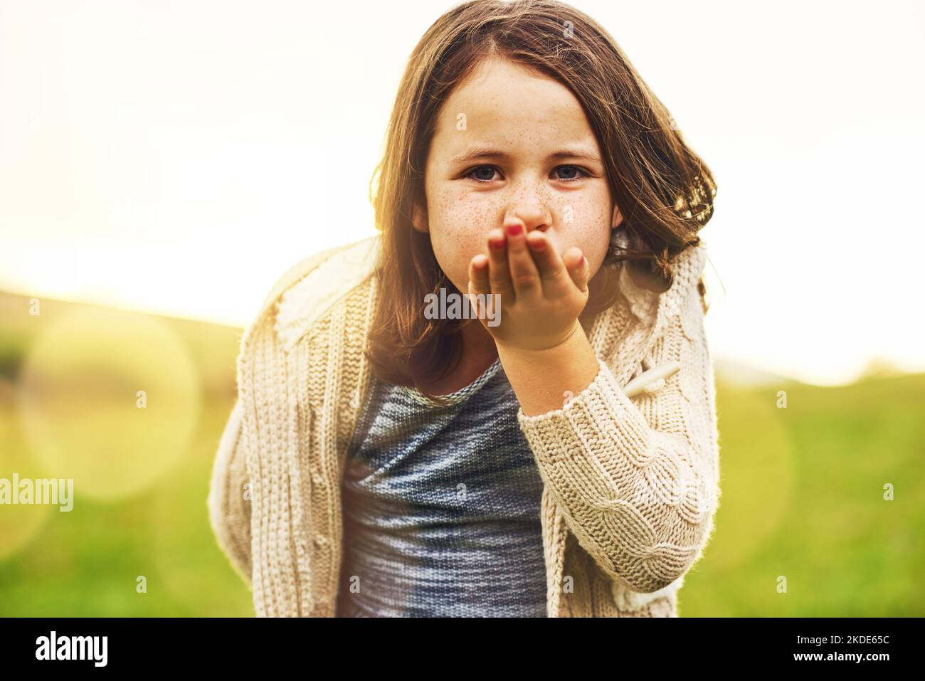 Kisses coming your way. Portrait of a sweet little girl blowing a kiss ...