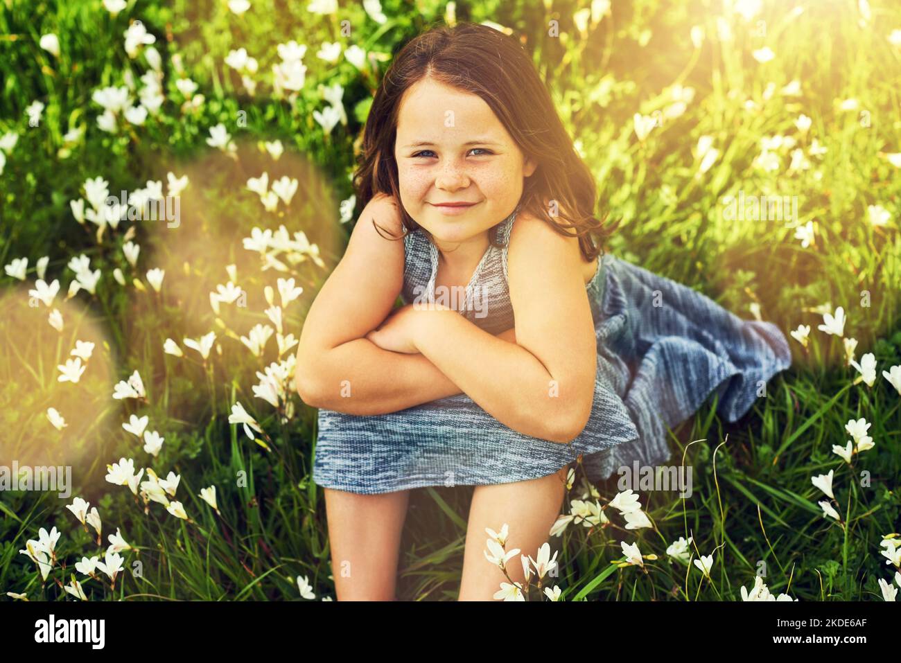 Shes a little flower child. Portrait of a sweet little girl sitting in ...