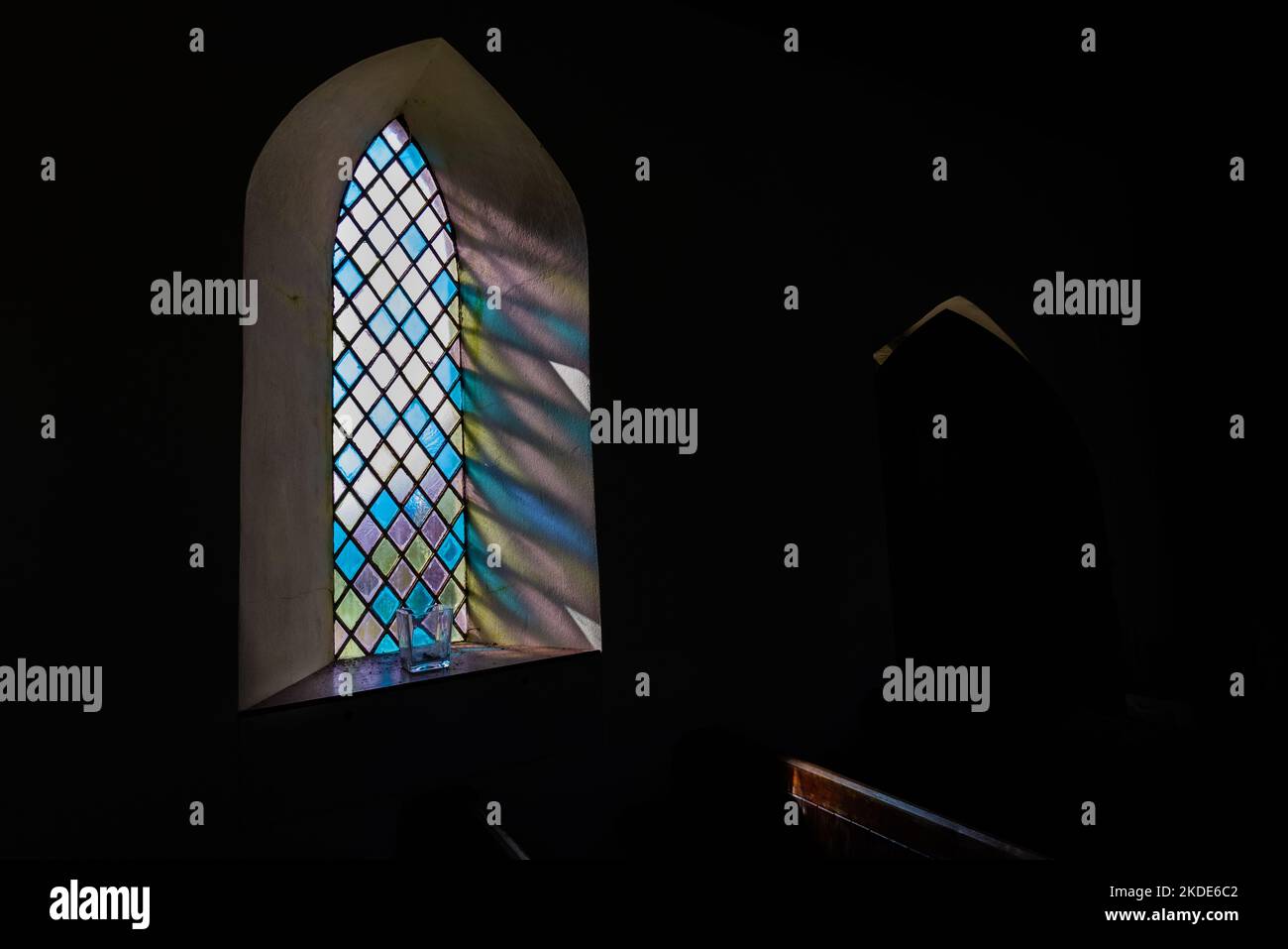 Light shining through stained glass window of small chapel with very ...